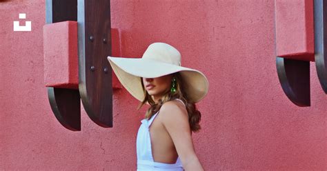 노란 태양 모자를 쓰고 파란색과 흰색 민소매 드레스를 입은 여자 사진 Unsplash의 무료 유행 이미지