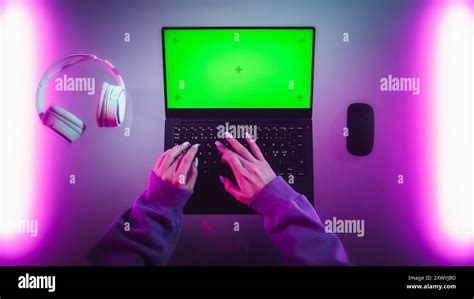 Top Down Shot Of A Female Software Developer Working On A Laptop In Stylish Room With Neon