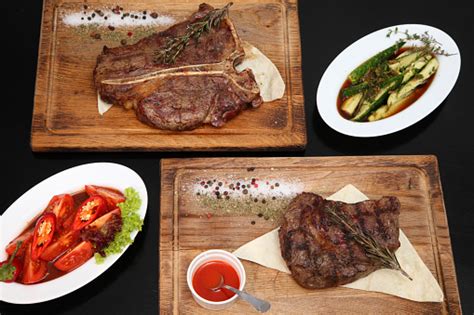 나무 접시에 쇠고기 스테이크 중간 크기의 스테이크는 소스와 조미료를 곁들인 나무 판에 조각으로 자릅니다 맛있는 스테이크 Steakhouse에 대한 스톡 사진 및 기타 이미지