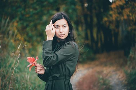 황금 단풍 중 여성의 아름다움 초상화 Bokeh에 노란 나뭇잎과가을 배경에 긴 자연 검은 머리를 가진 꿈꾸는 아름 다운 시골 소녀 가을 숲에서 소녀의 손에 낙 엽 가을에