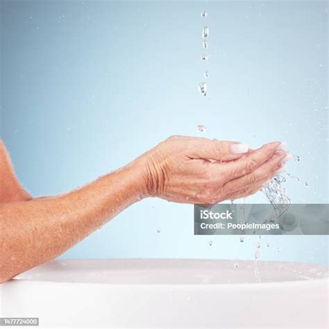 깨끗한 위생을 위해 노인의 손 물과 씻기 신선한 미네랄 또는 스튜디오 배경에 물보라 세면대나 세면대에서 피부 수분 공급 웰빙 또는 스킨케어를 위한 천연 액체를 들고 있는