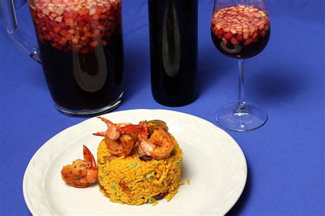 새우 사프란 닭고기 해산물 채소로 준비한 빠에야 쌀 발렌시아 스페인의 전통 요리 청색 배경에 있는 성직자 투수와 유리 Clericot에 대한 스톡 사진 및 기타 이미지