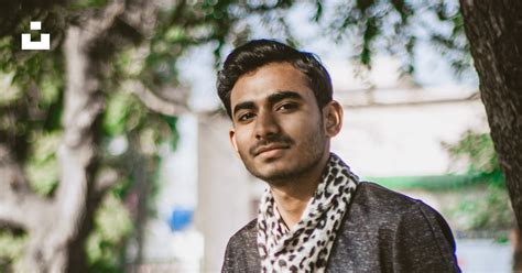 검은 블레이저와 파란색 데님 청바지를 입은 남자가 콘크리트 벤치에 앉아 있다 사진 Unsplash의 무료 파키스탄 이미지