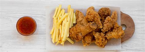 맛 있는 패스트 푸드 후 라 이드 치킨 나지만 매운 날개 감자 튀김 및 닭 흰색 나무 표면 최고 보기에 새 콤 달콤한 소스와 함께 제거 합니다 평면 오버 헤드 위에서 누워