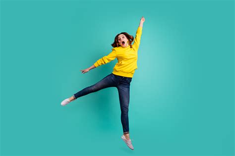 풀 길이 바디 사이즈 사진 의 황홀 한 기뻐 곱슬 물결 모양의 흰색 젊은이 착용 청바지 데님 기뻐 비행 으로 파라솔 고립 된 청록색 선명한 색상 배경 바람에 대한 스톡 사진