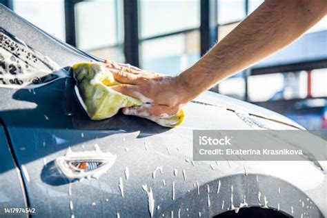 한 남자가 셀프 서비스 세차장에서 거품으로 차를 씻고 클로즈업합니다 40 44세에 대한 스톡 사진 및 기타 이미지 40 44