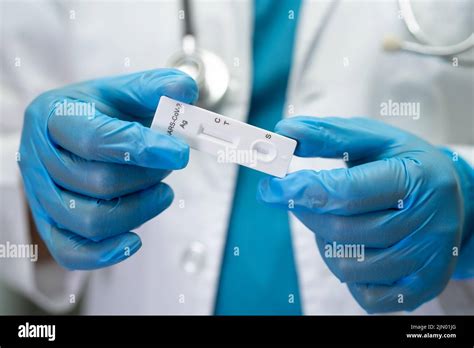 Asian Doctor In PPE Suit Show Positive Test Result With Saliva Antigen Test Kit For Check Covid