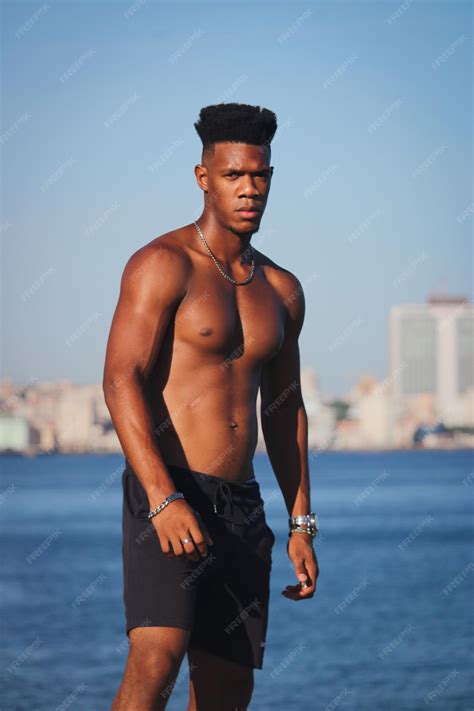 Premium Photo Young Shirtless Man Stands Behind The Sea And Wears