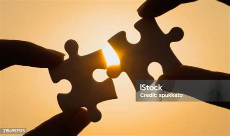 햇빛 효과 위에 직소 퍼즐 조각을 연결하는 클로즈업 손의 실루엣 협회 성공 및 연결 개념의 상징 비즈니스 전략 커플에 대한 스톡