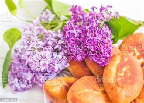 Piroshki 양배추 충전재와 라일락의 꽃다발 러시아어 구운 퍼프 페이스트리 전통적인 러시아 양배추 박제 구운 과자 양배추와 마른 파이 양배추와 아름다운 수제 케이크 가득