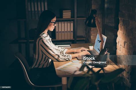 사진 의 놀라운 아시아 비즈니스 레이디 수완 사람 찾고 노트북 에 테이블 쓰기 보고서 앉아 보스 의자 정장 셔츠 밤 어두운 현대 사무실 갈색 머리에 대한 스톡 사진 및 기타