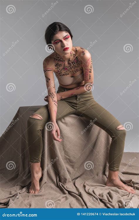 Young Brunette Cute Slim Model In Skinny Jeans Leaning Forward Stock