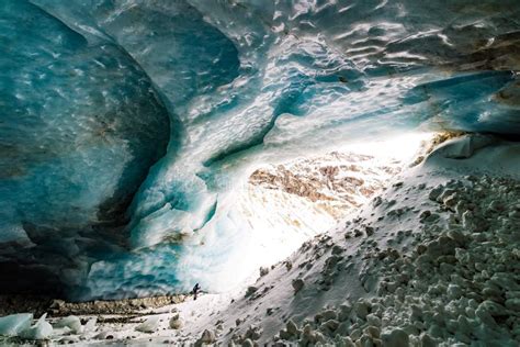 Hiker With Snowshoes Exit Zinal Glacier Cave In Switzerland Stock Image