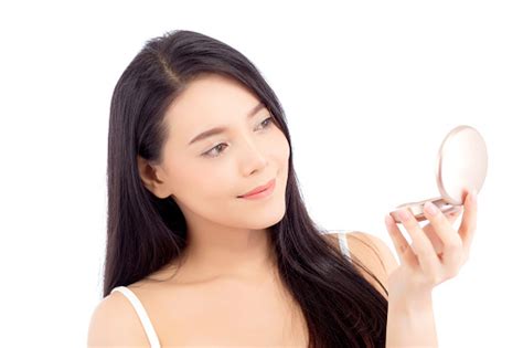 여자 얼굴의 화장품 아름다움의 뺨 메이크업에서 파우더 퍼프를 적용 하는 아름 다운 아시아 여자의 미소에 고립 된 흰색 배경 웰빙