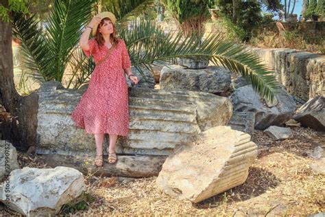 A Woman Tourist Sits On An Ancient Fallen Column The Girl In The Straw