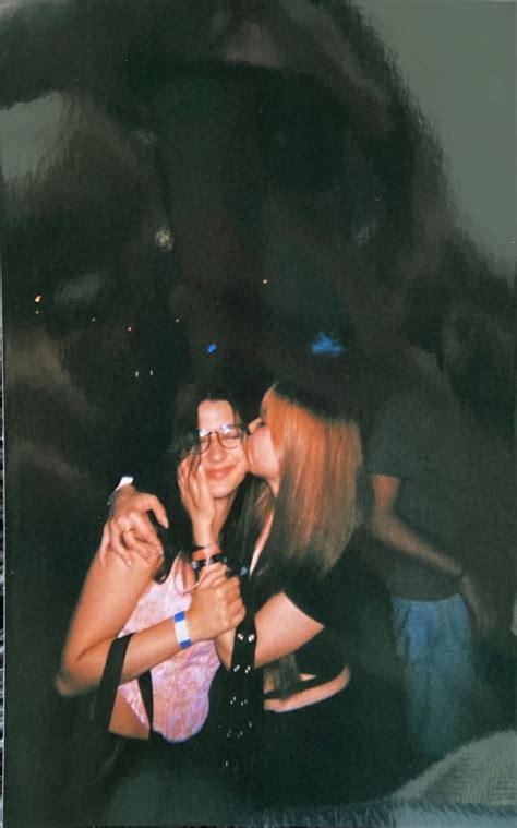 Two Women Kissing Each Other In Front Of A Black Bear