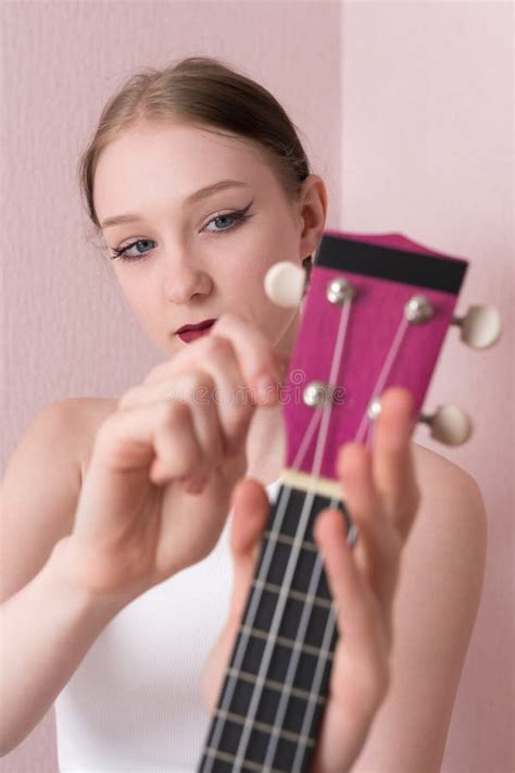 Woman Musician Holding Ukulele Tuning Musical Instrument Tightening And Loosening Strings