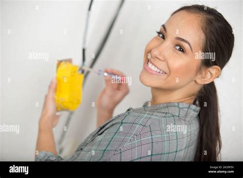 Woman Testing Electrical Junction Box With A Screwdriver Stock Photo Alamy