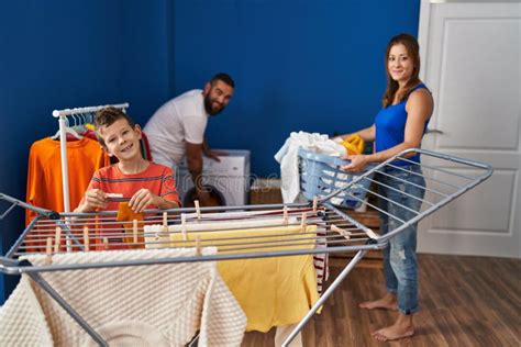 Family Smiling Confident Doing Laundry At Laundry Room Stock Image