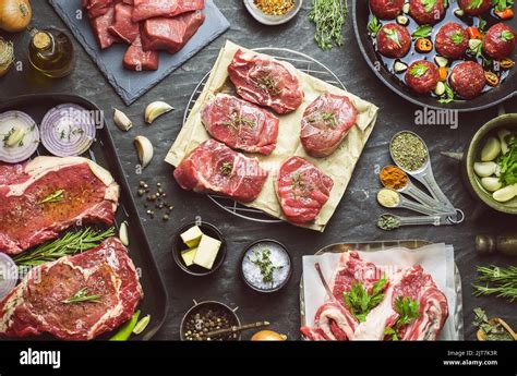 Different Types Of Fresh Raw Meat Sprinkled With Seasonings And Placed With Organic Ingredients