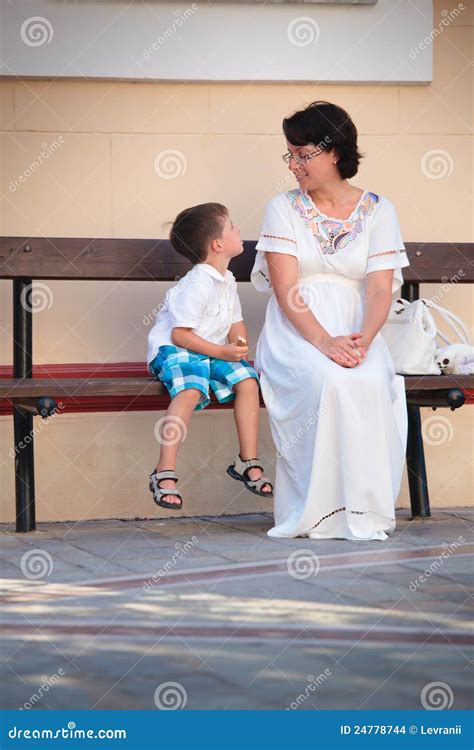 Madre Feliz E Hijo Que Se Sientan En Banco Foto De Archivo Imagen De Feliz Adulto
