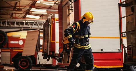 용감한 소방관이 완전한 보호복을 입고 소방서에 서서 행동을 준비하고 있다 사진 Unsplash의 자부심 이미지