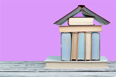 펼쳐진 책 나무 테이블과 보라색 배경에 있는 양장본 다채로운 책들 학교로 돌아 가기 텍스트를 위한 공간을 복사합니다 교육 사업 개념입니다 성장 개념에 대한 스톡 사진 및