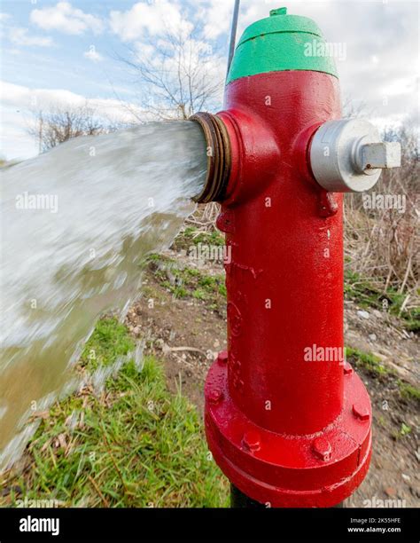 Water Flowing From An Open Red Fire Hydrant Closeup Side View The Top