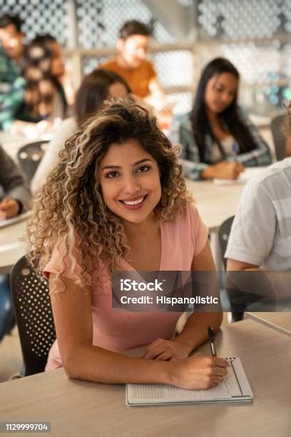 카메라 웃 고 직면 하는 수업 중 곱슬 머리를 가진 아름 다운 라틴 아메리카 학생의 초상화 교실에 대한 스톡 사진 및 기타 이미지 교실 대학생 여자 Istock