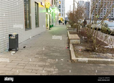 Garbage Bins In The Yard An Overflowing Urn Near The Entrance Of An Apartment Building Stock