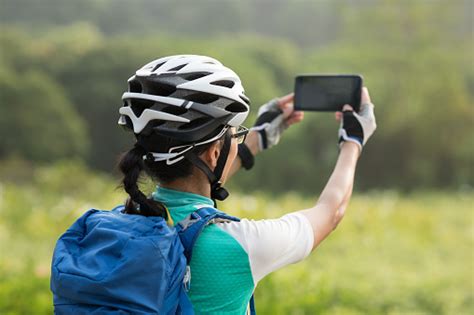 공원에서 화창한 날에 자전거를 타고있는 동안 스마트 폰을 사용하여 사진을 찍는 여성 건강한 생활방식에 대한 스톡 사진 및 기타 이미지 건강한 생활방식 내비게이션 두발