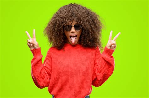 손가락으로 혀와 만들기 승리 기호를 보여주는 카메라를 보고 하는 선글라스를 착용 하는 아프리카계 미국인 여자 검안에 대한 스톡 사진 및 기타 이미지 Istock