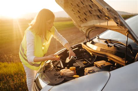 신호 조끼를 입은 젊은 여성이 자동차 엔진에 모터 오일을 붓습니다 고속도로에서 자동차 고장 봄에 대한 스톡 사진 및 기타 이미지 Istock