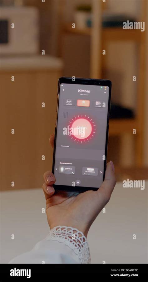 Female Holding Smartphone With Lighting Control Application Turning On