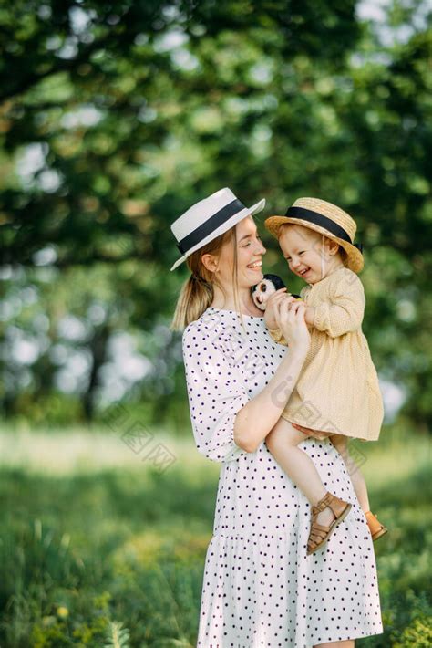 妈妈和女儿戴着帽子在公园里散步玩得很开心图片 包图网企业站
