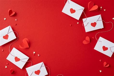 강렬한 발렌타인 데이 분위기로 사랑과 애정을 상징하는 빨간색 배경에 하트 디자인이 있는 봉투를 전시합니다 로맨틱한 축하 행사와 진심 어린 감정을 표현하는 데 적합합니다 0