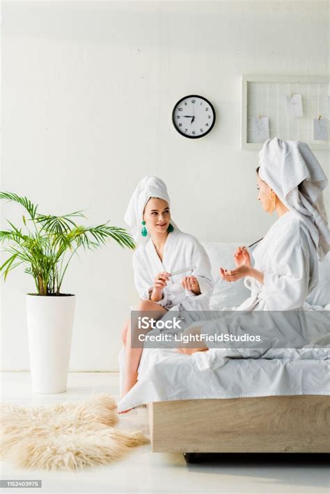 목욕 가운과 보석의 세련 된 여성 침대에 앉아 머리에 수건 이야기 하 고 바닥에 녹색 식물과 모피 근처에 손톱을 제출 2명에 대한 스톡 사진 및 기타 이미지 Istock