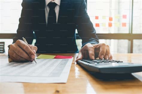 닫다 사업가 또는 변호사 회계사는 계산기를 사용하여 계정을 작업하고 문서에 글을 씁니다 사진 Unsplash의 펜 이미지