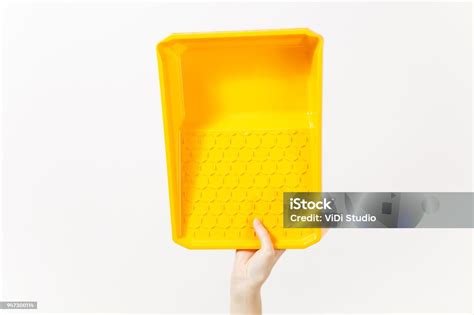 여성 손 수직 보유 흰색 배경에 고립 된 오렌지 페인트 트레이 닫습니다 기기 액세서리 재건축 아파트 룸에 대 한 도구 수리 가정 개념입니다 광고에 대 한 공간을 복사 합니다