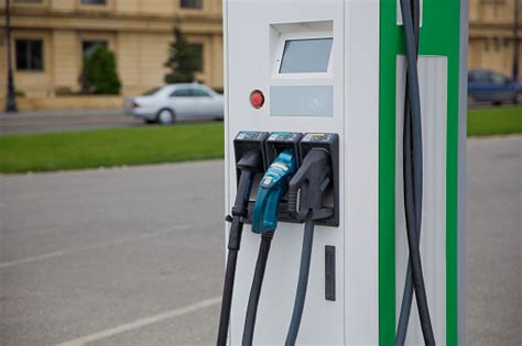 전기 자동차 클로즈업 충전을위한 두 개의 권총패널 도시 거리 야외에서 차량에 전기를 충전하는 충전기가있는 에코 카용 전기 충전