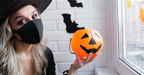 검은 마녀 의상을 입은 슬픈 금발과 얼굴 마스크가 창문 밖을 바라 봅니다 코비드로부터 할로윈 보호 준비 10월에 대한 스톡 사진 및 기타 이미지 Istock