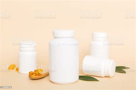 오메가 3 캡슐은 녹색 잎 배경이있는 테이블 위의 흰색 병에 놓여 있습니다 생선 기름 정제 생물학적 활성 첨가제 오메가 6 오메가 9 비타민 A E D 비타민 D3 상단