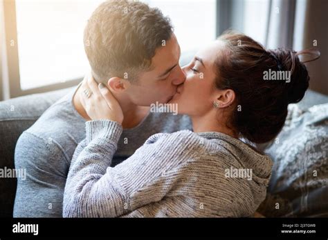 Passionate Kisses On The Couch Shot Of An Affectionate Young Couple