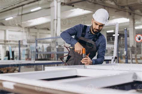 Factory Worker Assembling Aluminum Window Frames In Production Line
