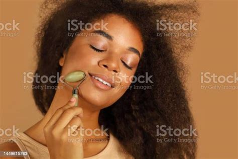 얼굴 옥 롤러를 피부 치료로 사용하여 눈을 감은 젊은 아프리카계 미국인 여성 16 17 살에 대한 스톡 사진 및 기타 이미지 16 17 살 갈색 곱슬 머리 Istock