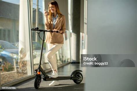 전기 스쿠터와 사무실 창 옆에 서서 휴대 전화를 사용하여 젊은 여자 안경에 대한 스톡 사진 및 기타 이미지 안경 20 24세 교통수단 Istock