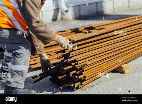 Slinger Stacks Thin Metal Pipes In Stack On Construction Site Close Up