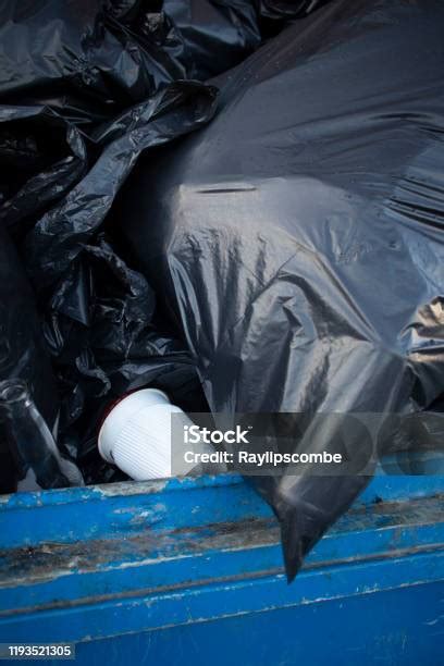 영국 글로스터셔 주 첼튼햄에 있는 상점 뒤쪽에서 버려진 골판지 검은 색 쓰레기통 라이너 및 종이로 가득 찬 쓰레기 쓰레기 쓰레기 쓰레기 바퀴통 0명에 대한 스톡 사진 및