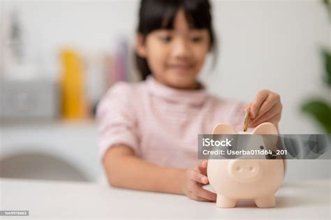 돼지 저금통에서 돈을 저축하고 저축에 대해 배우고 아이는 미래의 교육을 위해 돈을 절약합니다 돈 재정 보험 및 사람 개념 8 9 살에 대한 스톡 사진 및 기타 이미지