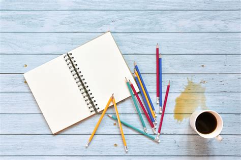 정물 비즈니스 교육 및 사고 개념 커피 유출 스플래시와 파란색 하늘 나무 배경에 빈 페이지와 다양한 다채로운 연필오픈 노트북의 최고 보기 이미지 텍스트를 추가하기위한 0명에